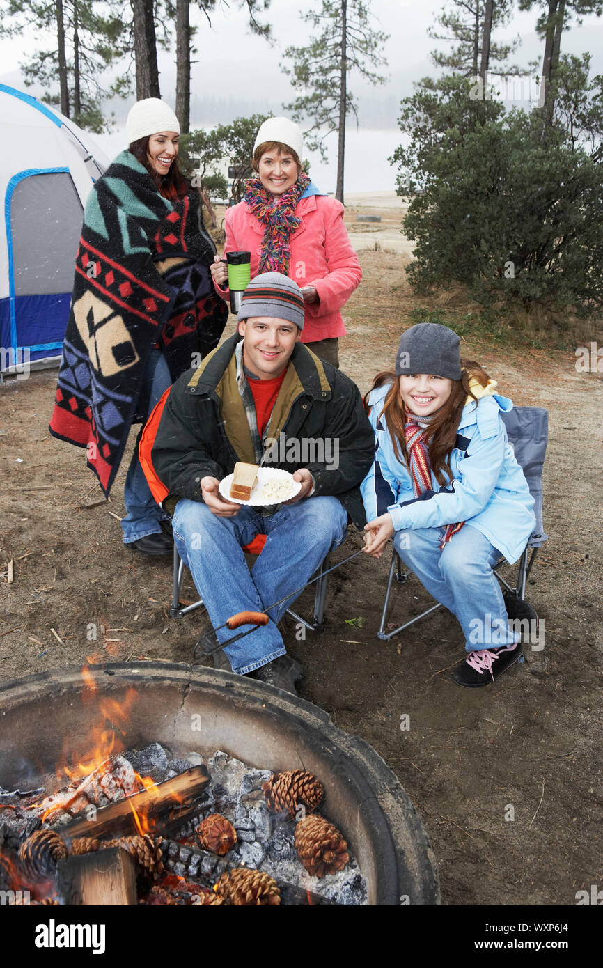 Happy Family At Campfire In Winter Stock Photo - Alamy
