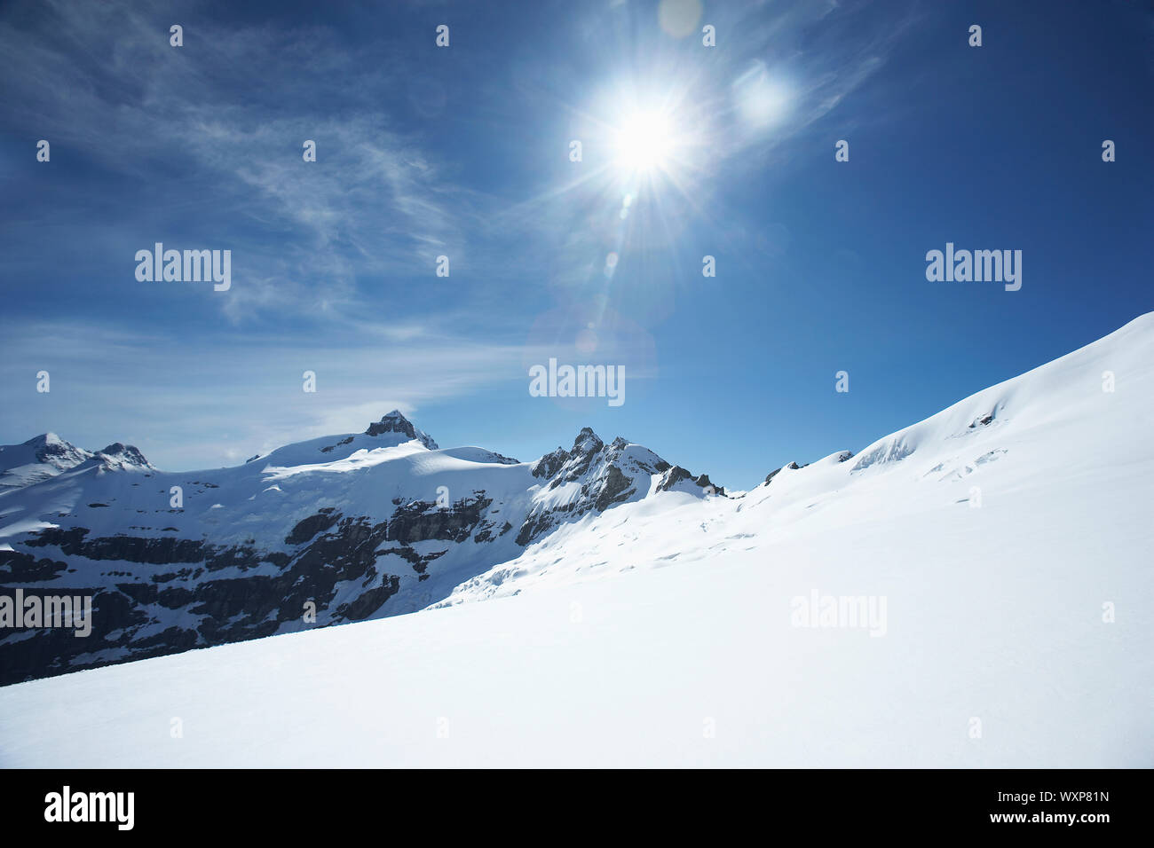 Snow-topped mountain peaks under the sun Stock Photo - Alamy