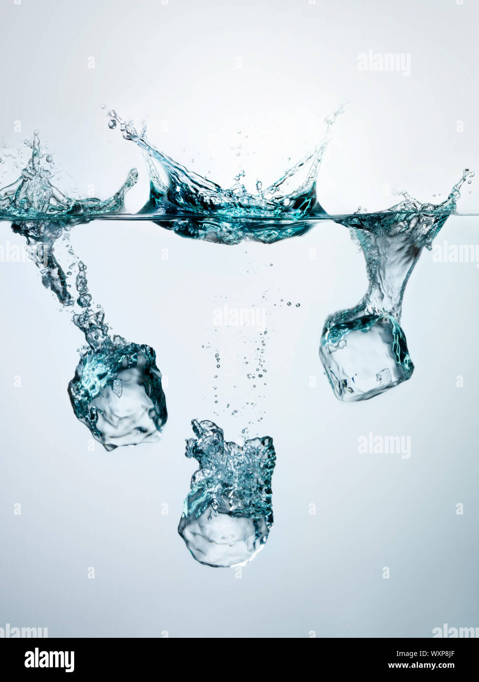 Ice cubes splashing into clear water surface view Stock Photo - Alamy
