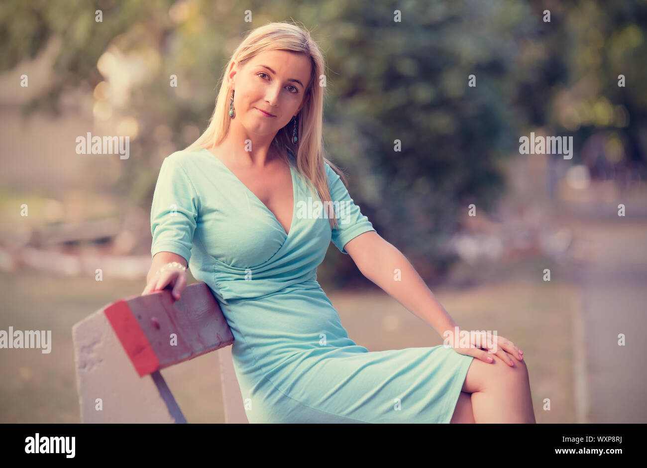 Beautiful woman sitting on bench in the street Stock Photo - Alamy