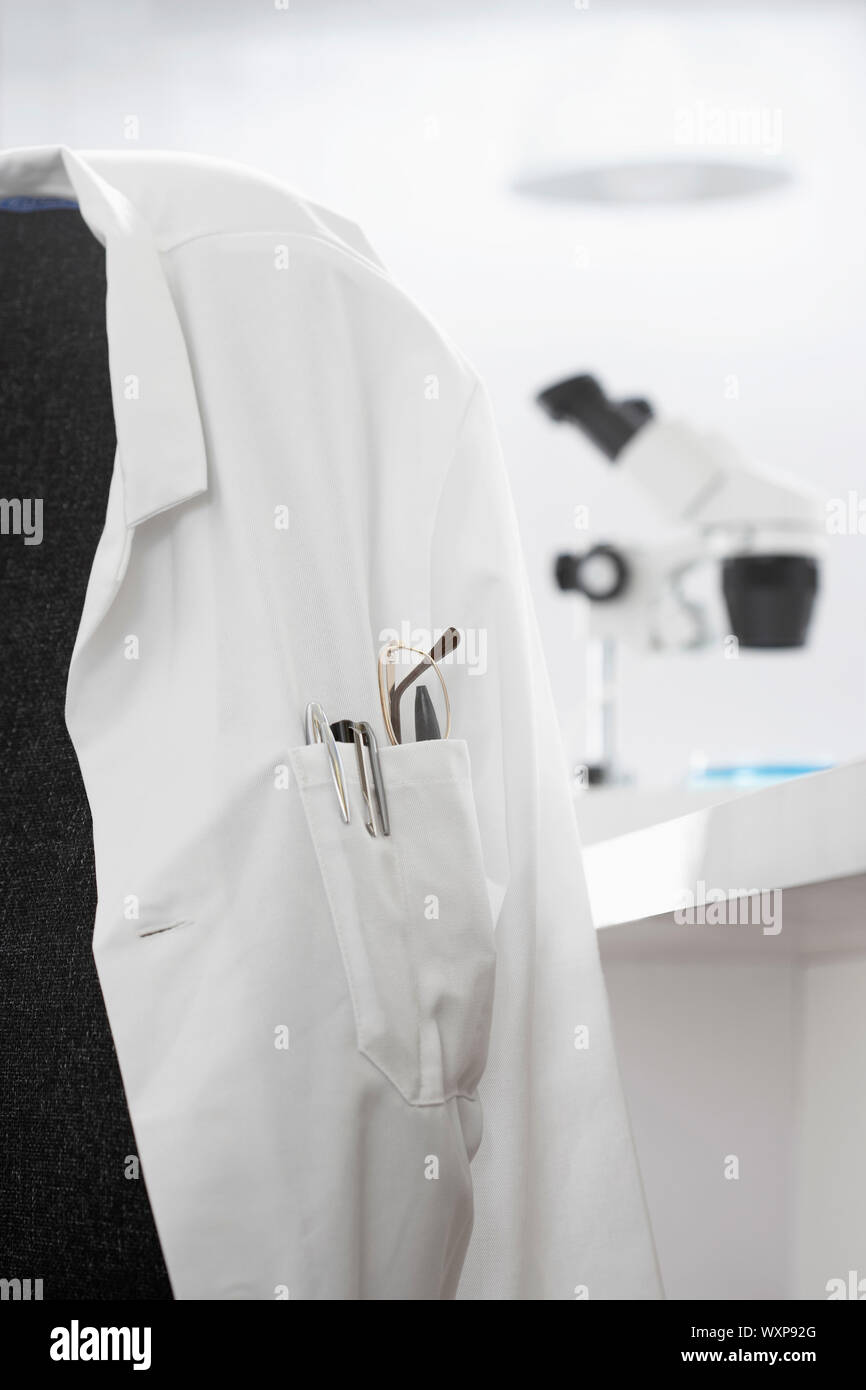 Scientists white coat in laboratory, with microscope in background ... Scientists white coat in laboratory, with microscope in background ...