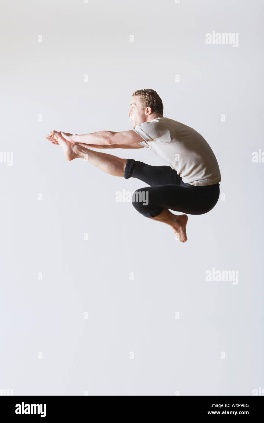Full length of male ballet dancer jumping over white background Stock ...