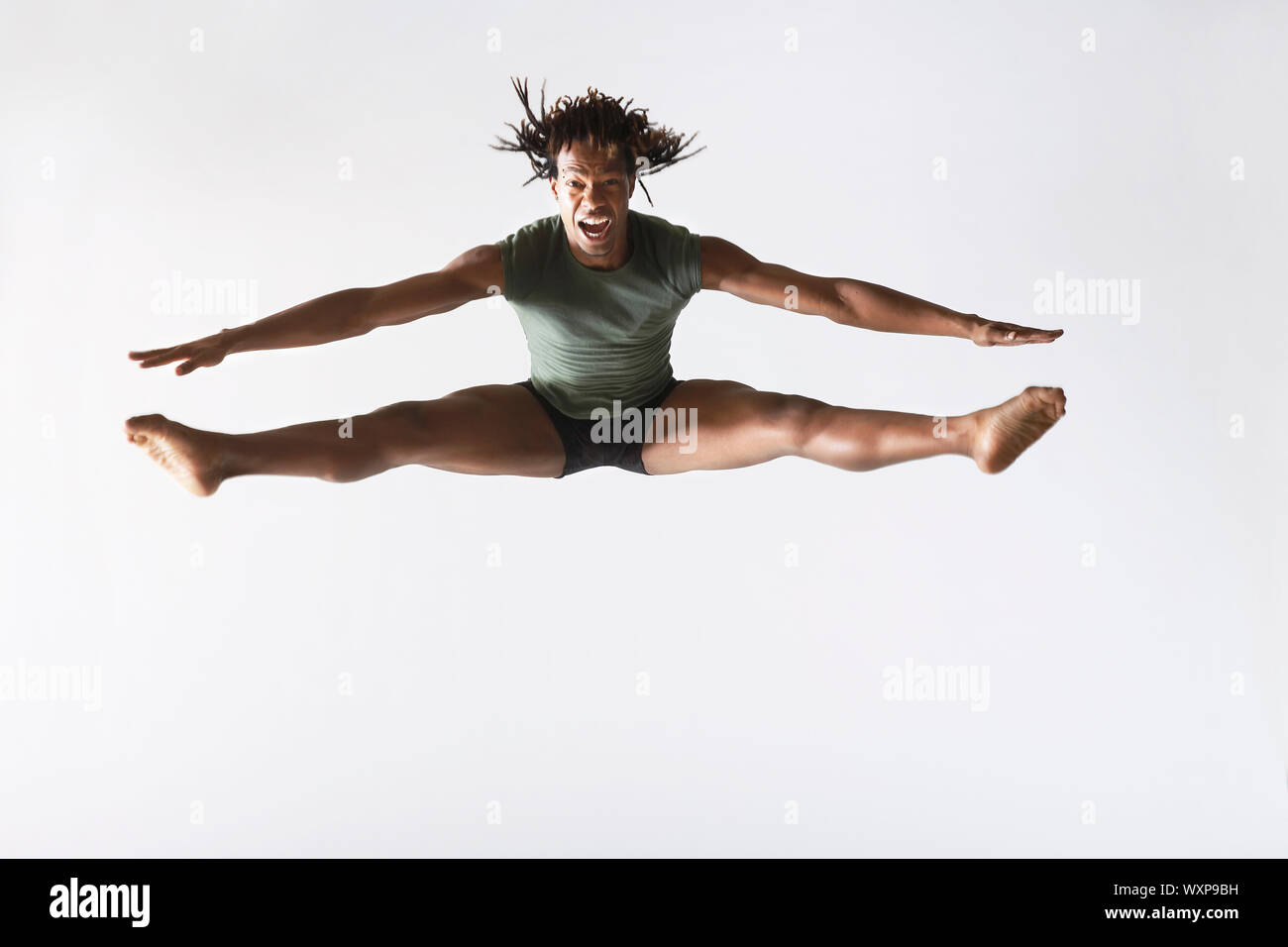 Full length of excited male ballet dancer jumping isolated on white ...