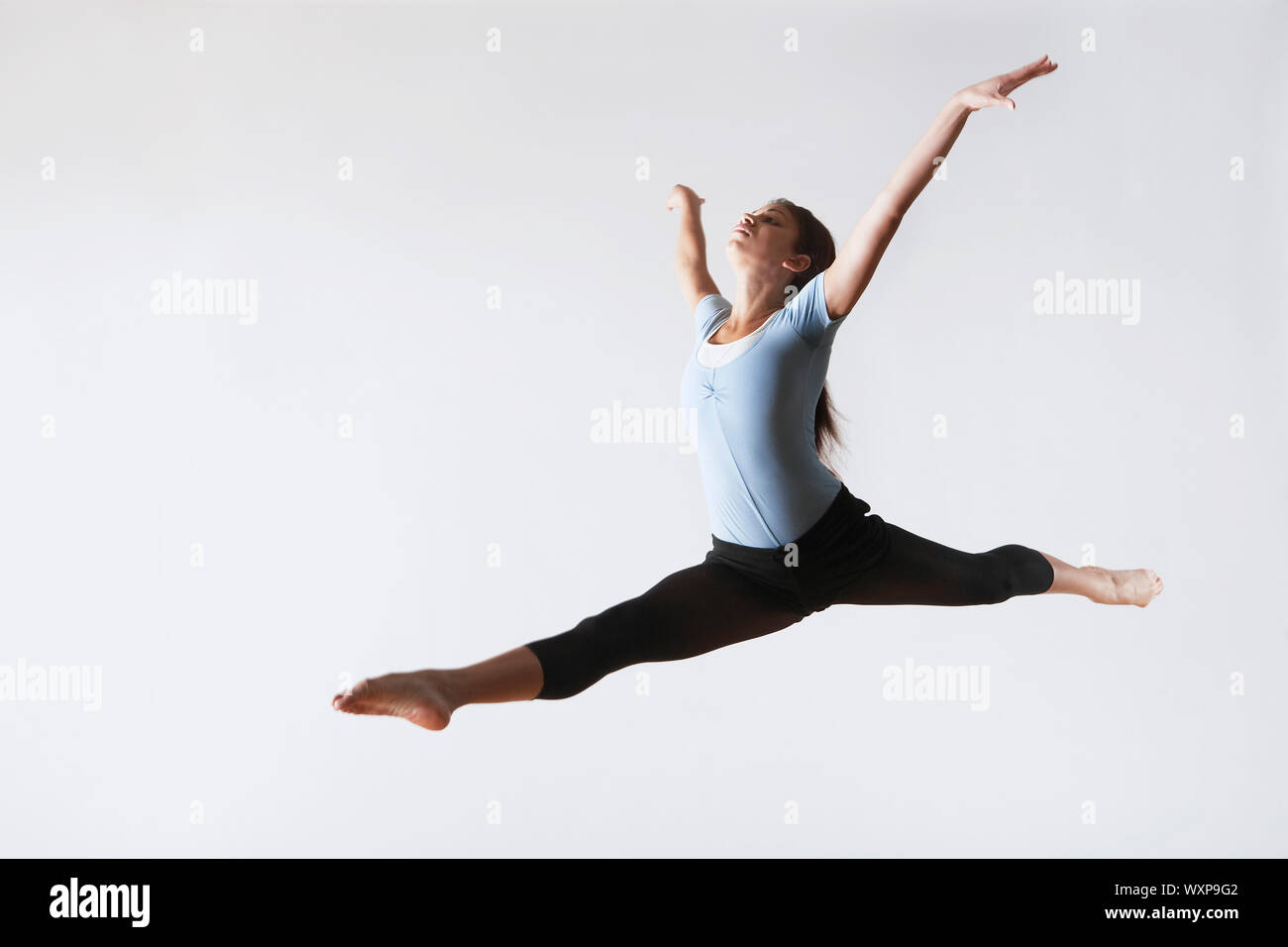 Full length of female ballet dancer leaping in mid air isolated on ...