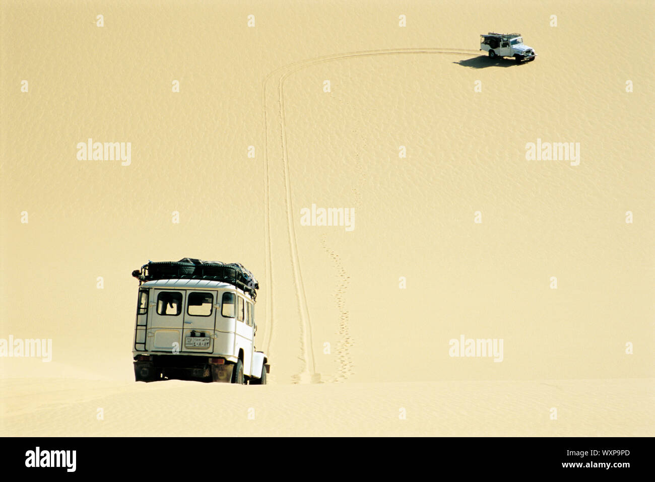 Safari vehicles driving in desert Stock Photo - Alamy