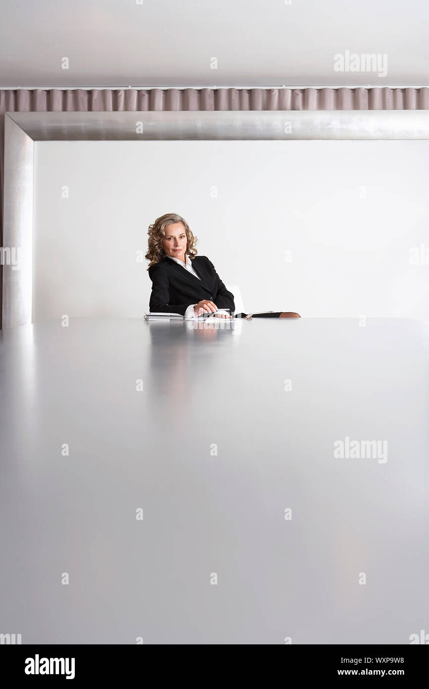 Portrait of confident female business executive sitting alone in ...