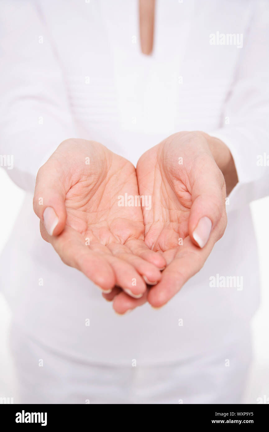 Closeup midsection of a woman cupping her hands against white ...