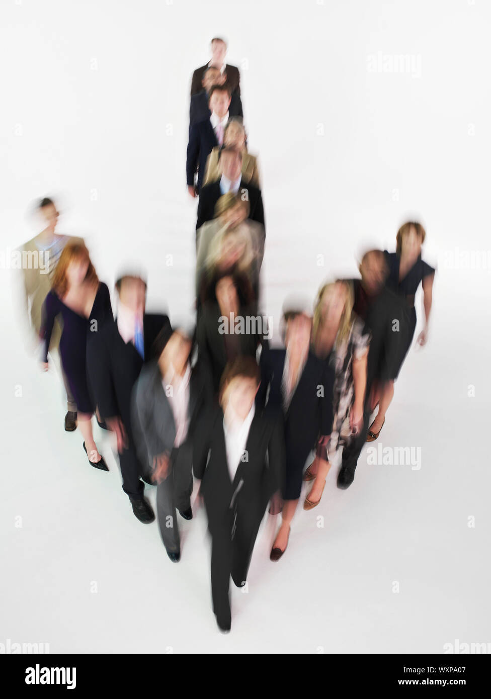 Blurred group of multiethnic businesspeople in arrow formation against ...