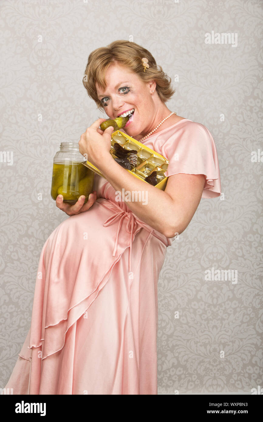 Grinning pregnant lady eating candy and pickles Stock Photo - Alamy