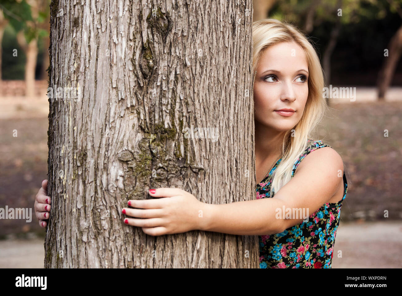 Outdoor portrait of a beautiful young girl embracing a tree Stock Photo ...