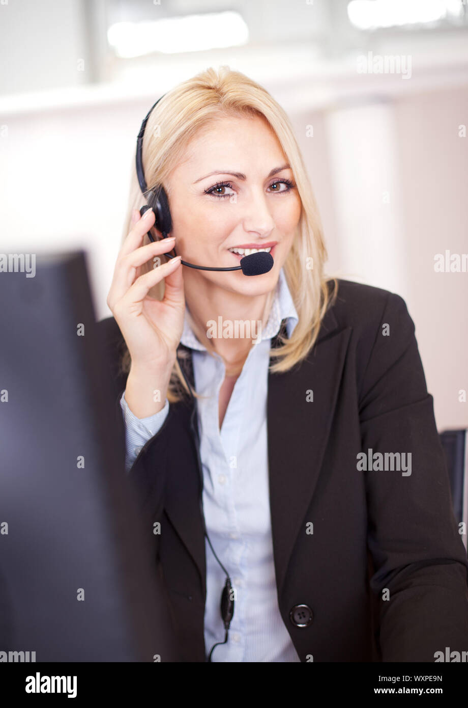 Beautiful call center operator talking over the phone in the office ...