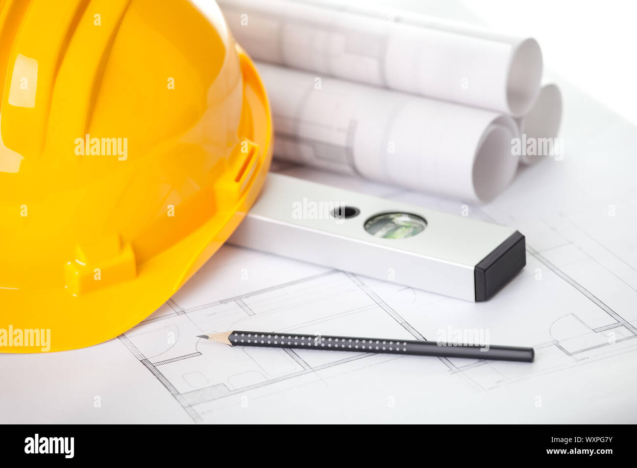 Image of yellow construction helmet with measuring level and site plan ...