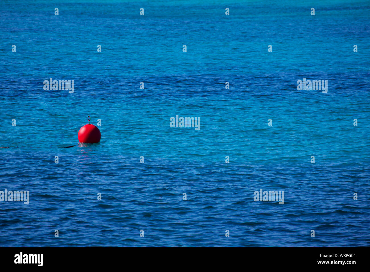 red buoy floating in blue mediterranean sea perspective Stock Photo - Alamy