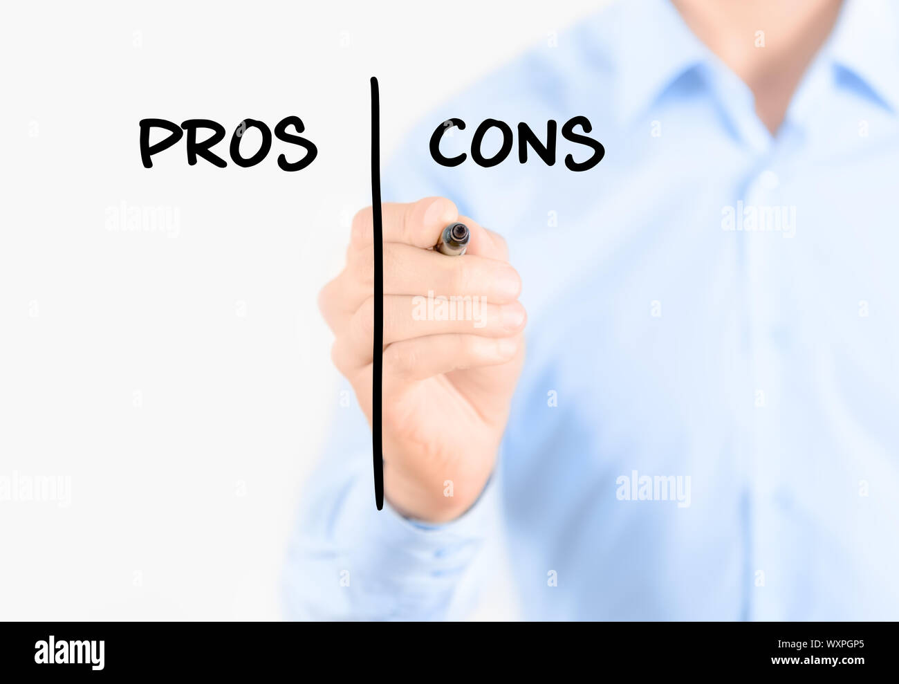 Young businessman holding a marker and writing pros and cons comparison ...