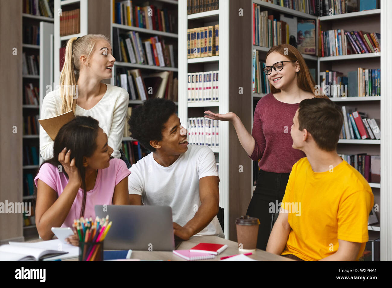 Friends doing homework at library together, sharing opinions Stock ...