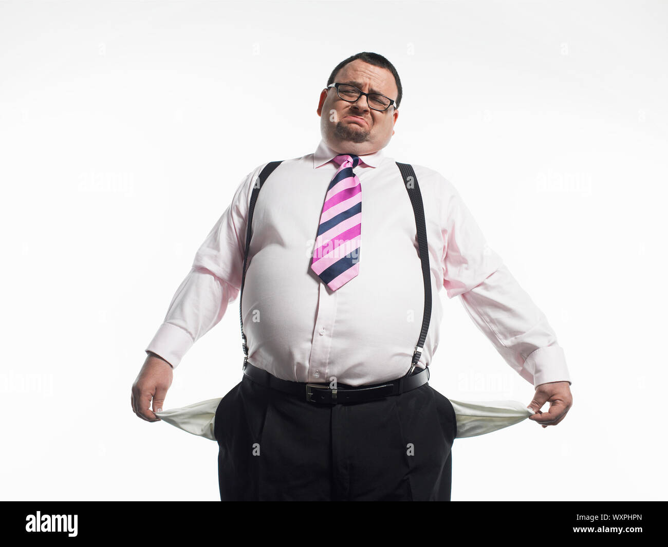 Portrait of an overweight businessman pulling out empty pockets against ...
