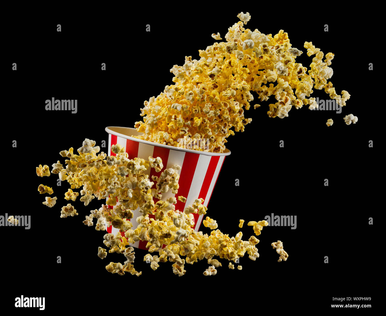 Flying popcorn from striped bucket isolated on black background Stock ...