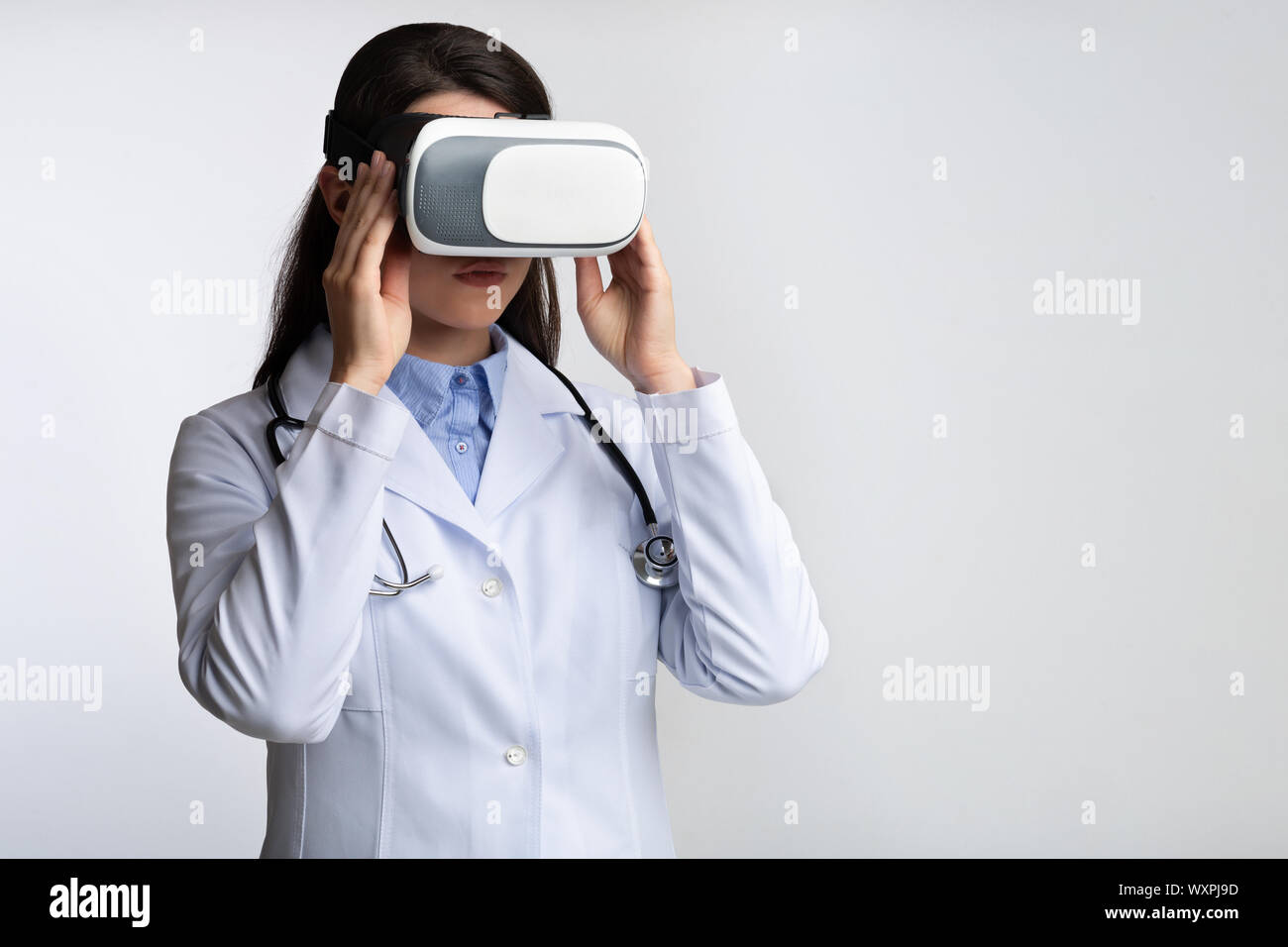 Lady Doctor Using Virtual Reality Headset In Studio Stock Photo - Alamy