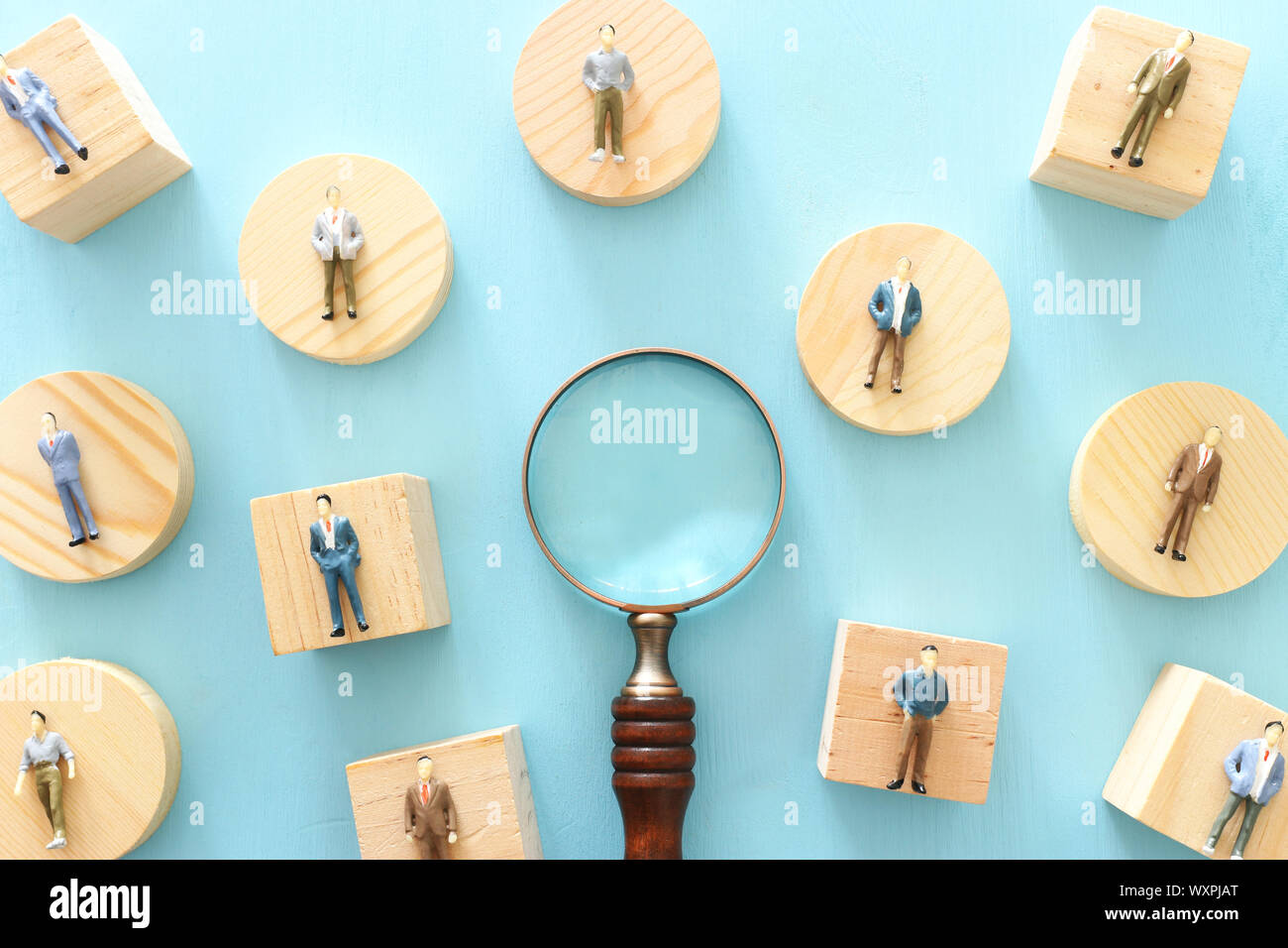 Business image of magnifying glass with people figures over blue ...