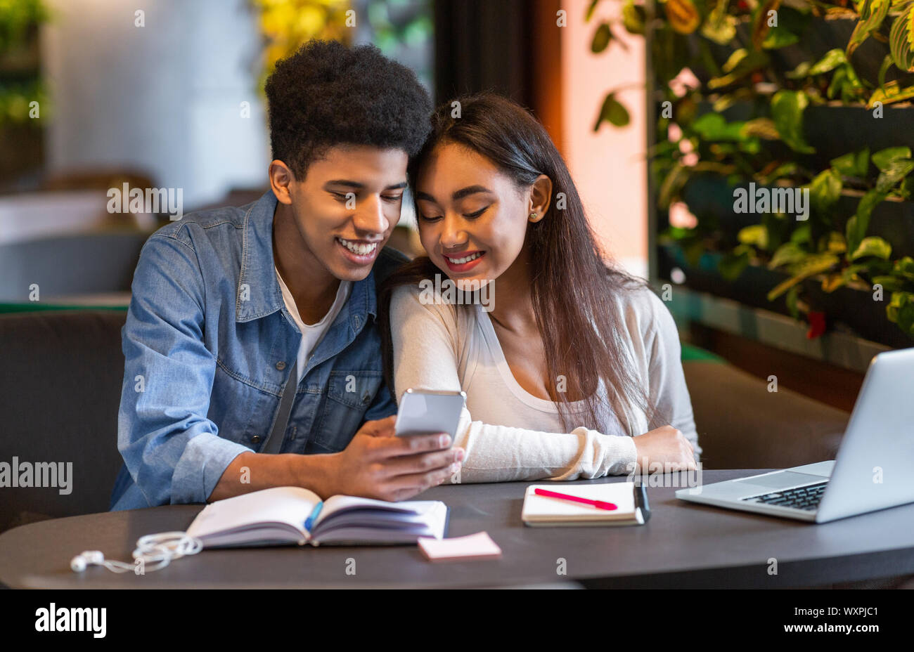 Happy students using mobile application for studying Stock Photo - Alamy