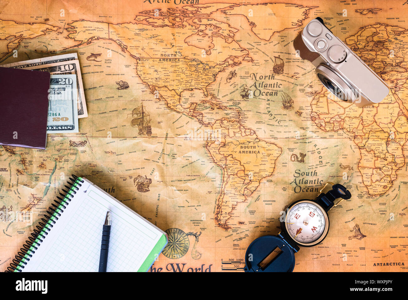 A traveler plans his trip around the world on an old map, while taking ...