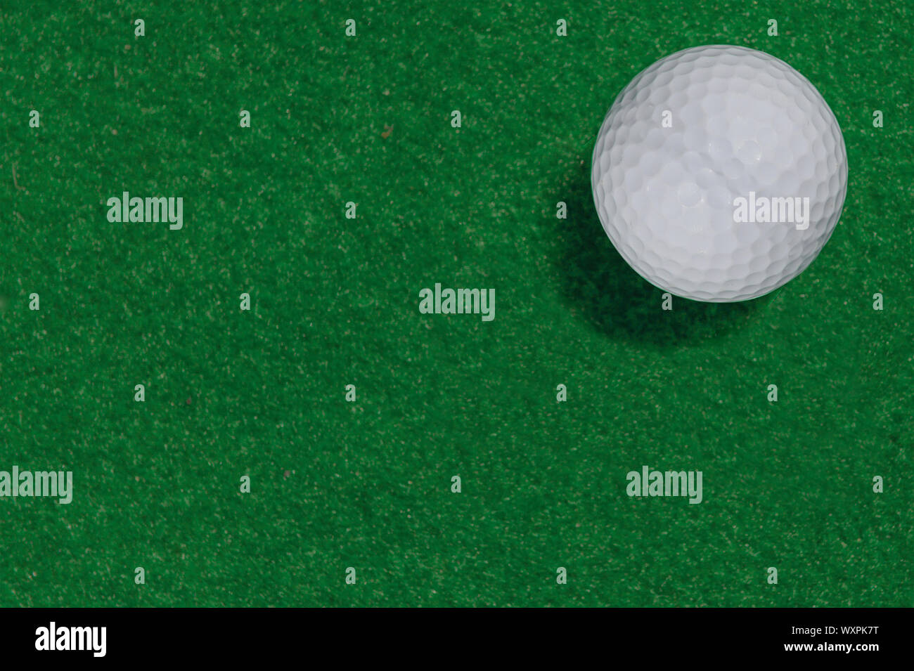 Golf ball on green texture background Stock Photo - Alamy