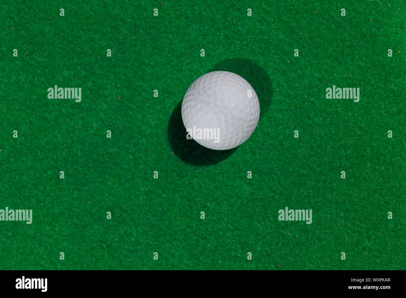 Golf ball on green texture background Stock Photo - Alamy