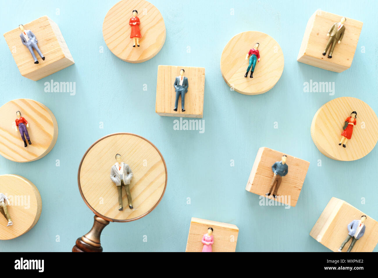 Business image of magnifying glass with people figures over blue ...