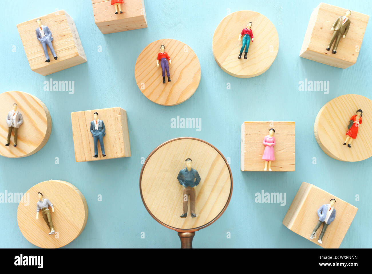 Business image of magnifying glass with people figures over blue ...