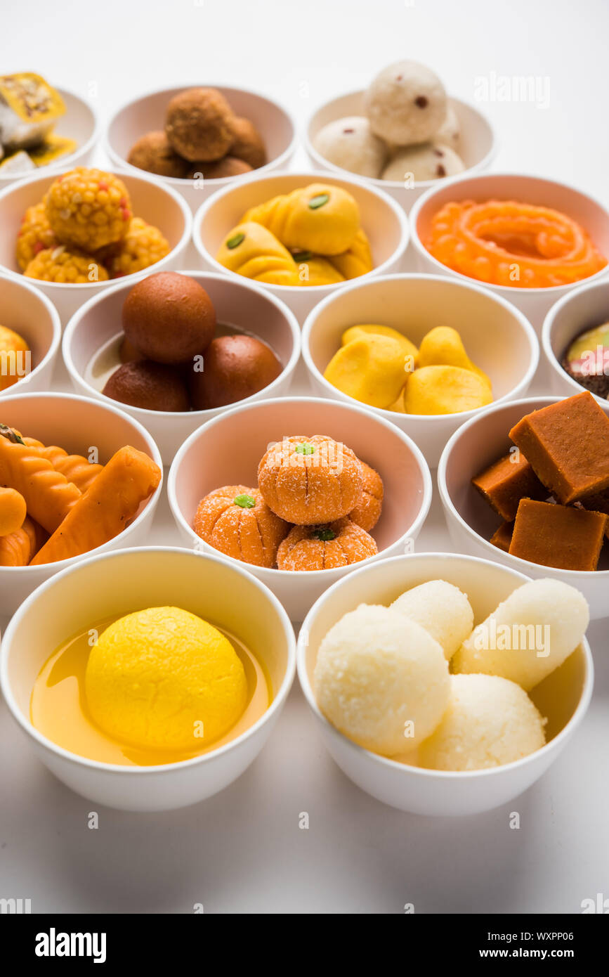 Rangoli of sweets and Farsan/snacks in bowls for Diwali with diya over ...
