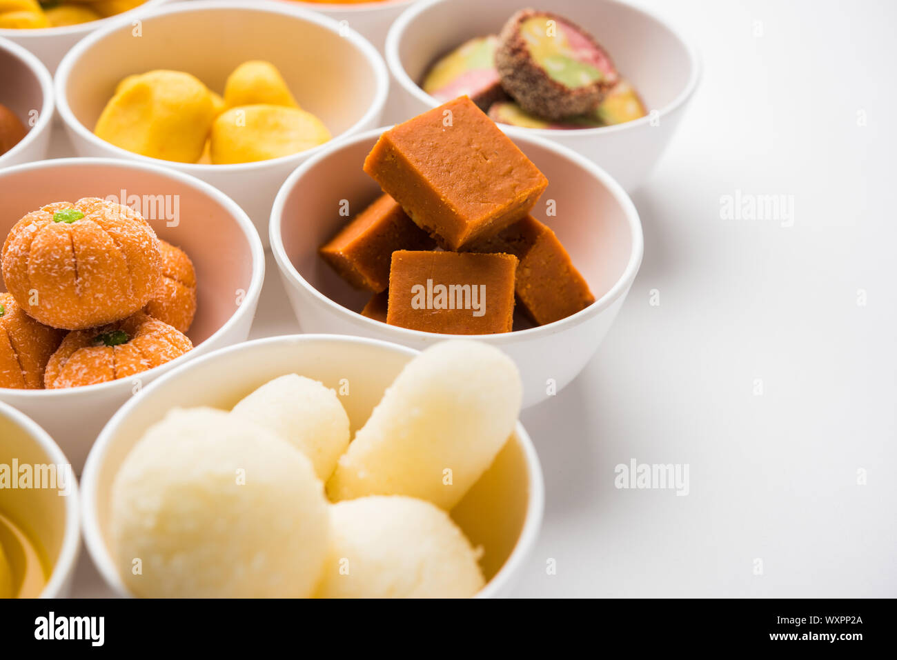 Rangoli of sweets and Farsan/snacks in bowls for Diwali with diya over ...