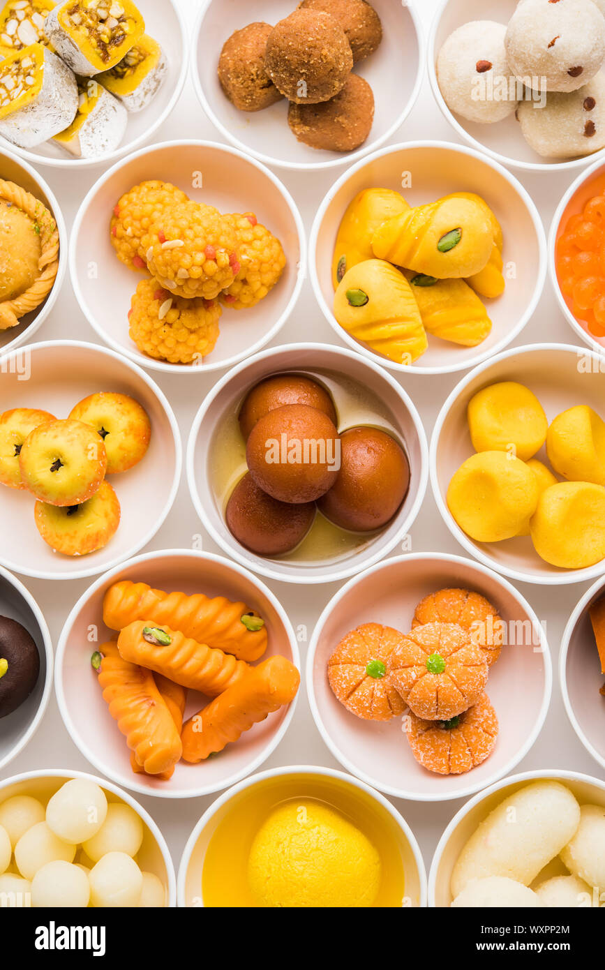 Rangoli of sweets and Farsan/snacks in bowls for Diwali with diya over ...
