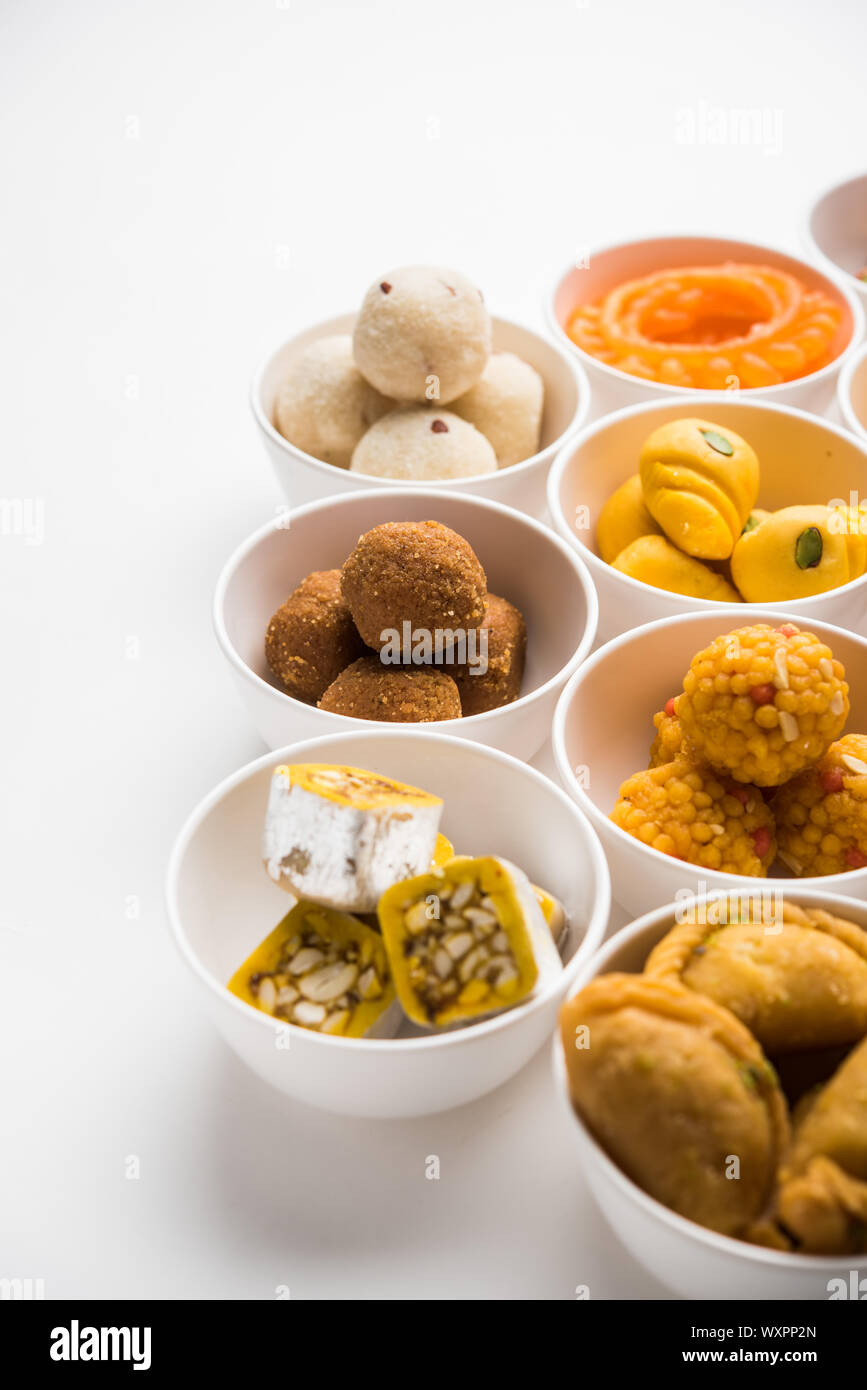 Rangoli of sweets and Farsan/snacks in bowls for Diwali with diya over ...