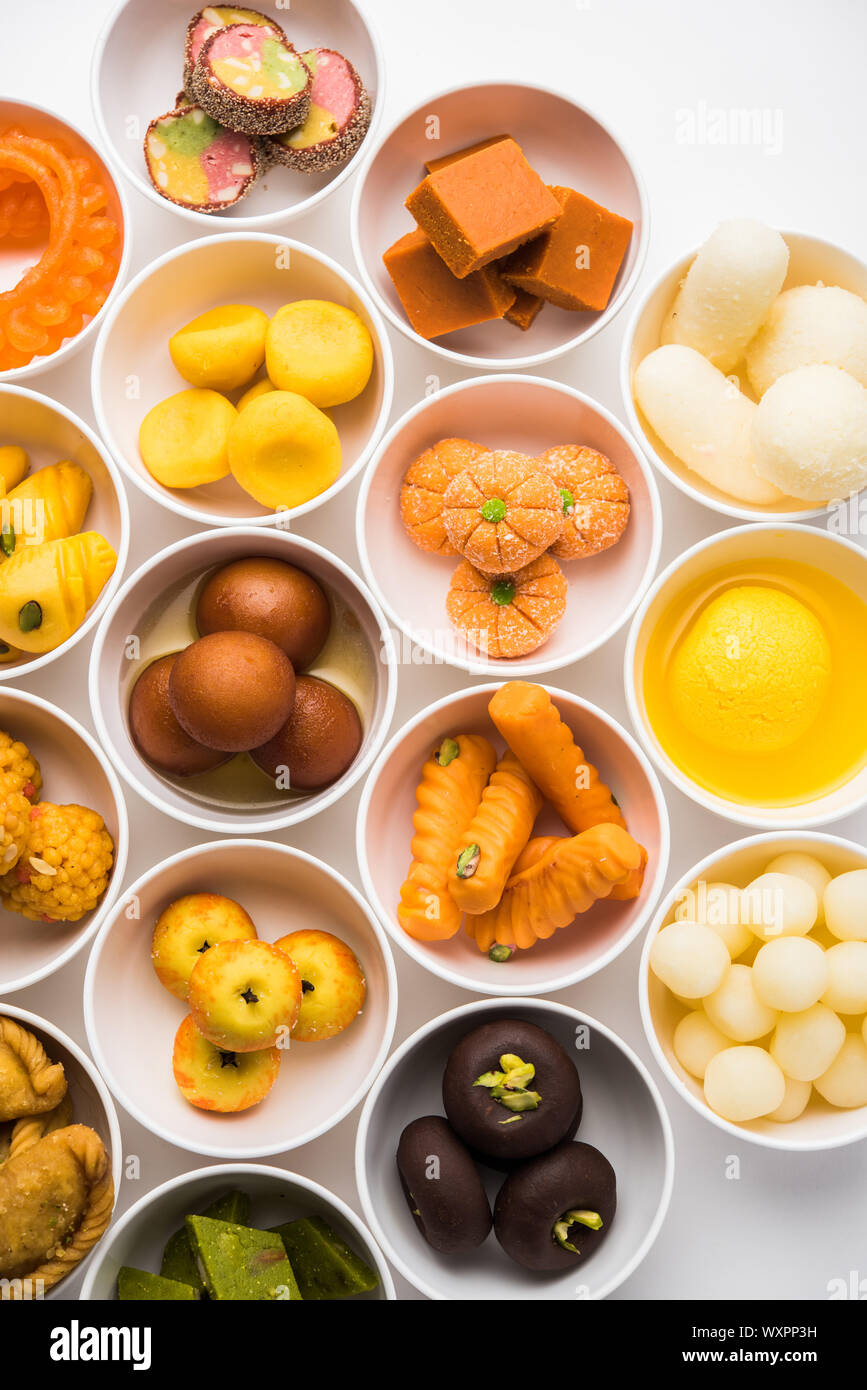 Rangoli of sweets and Farsan/snacks in bowls for Diwali with diya over ...