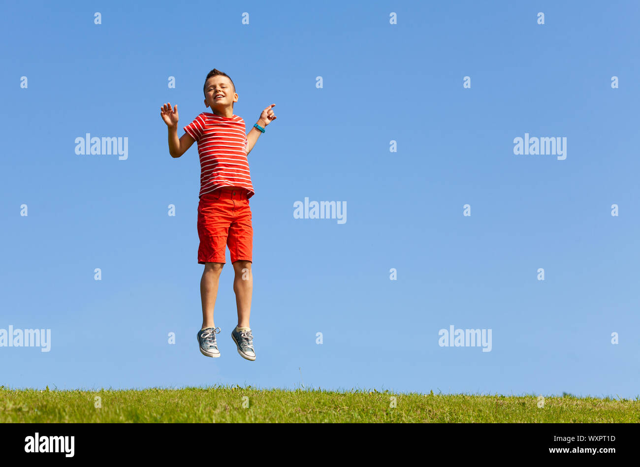 Boy jump high over sky lifting hands and smile Stock Photo - Alamy