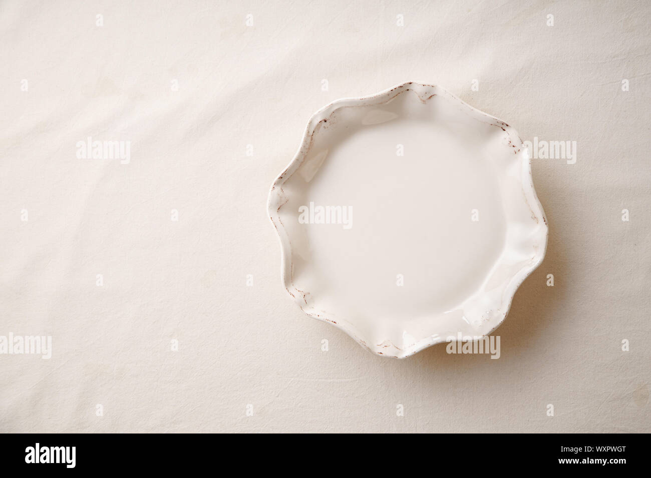 Porcelain plate on linen tablecloth. Overhead image, copy space ...