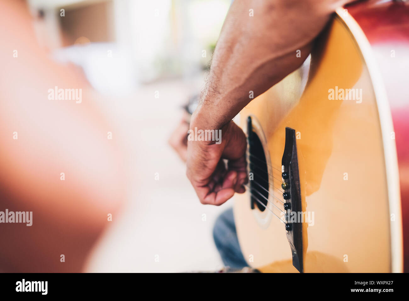 Man's left hand the strumming acoustic guitar. Selective focus. Copy ...