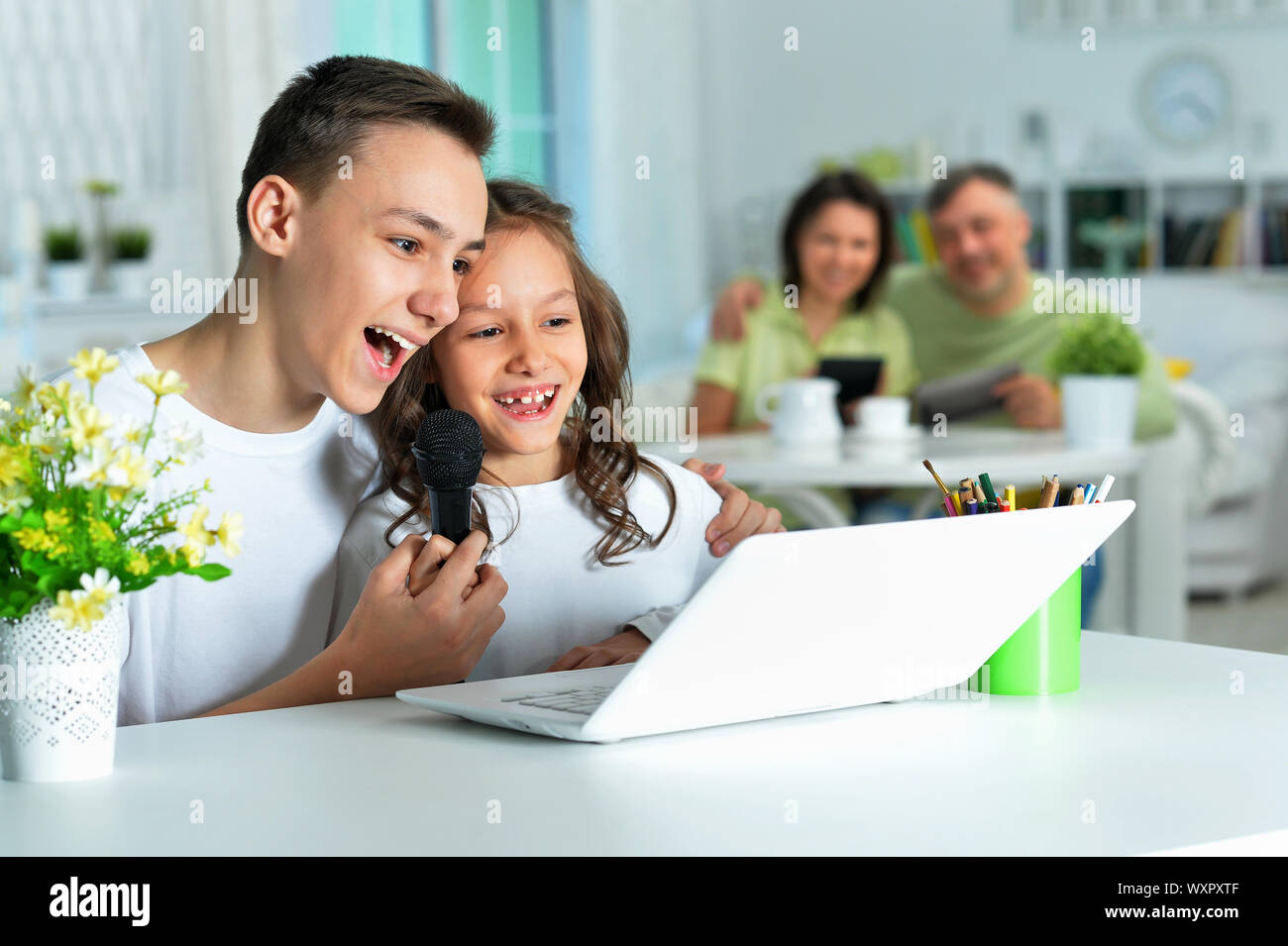 Happy brother and sister using modern laptop Stock Photo - Alamy