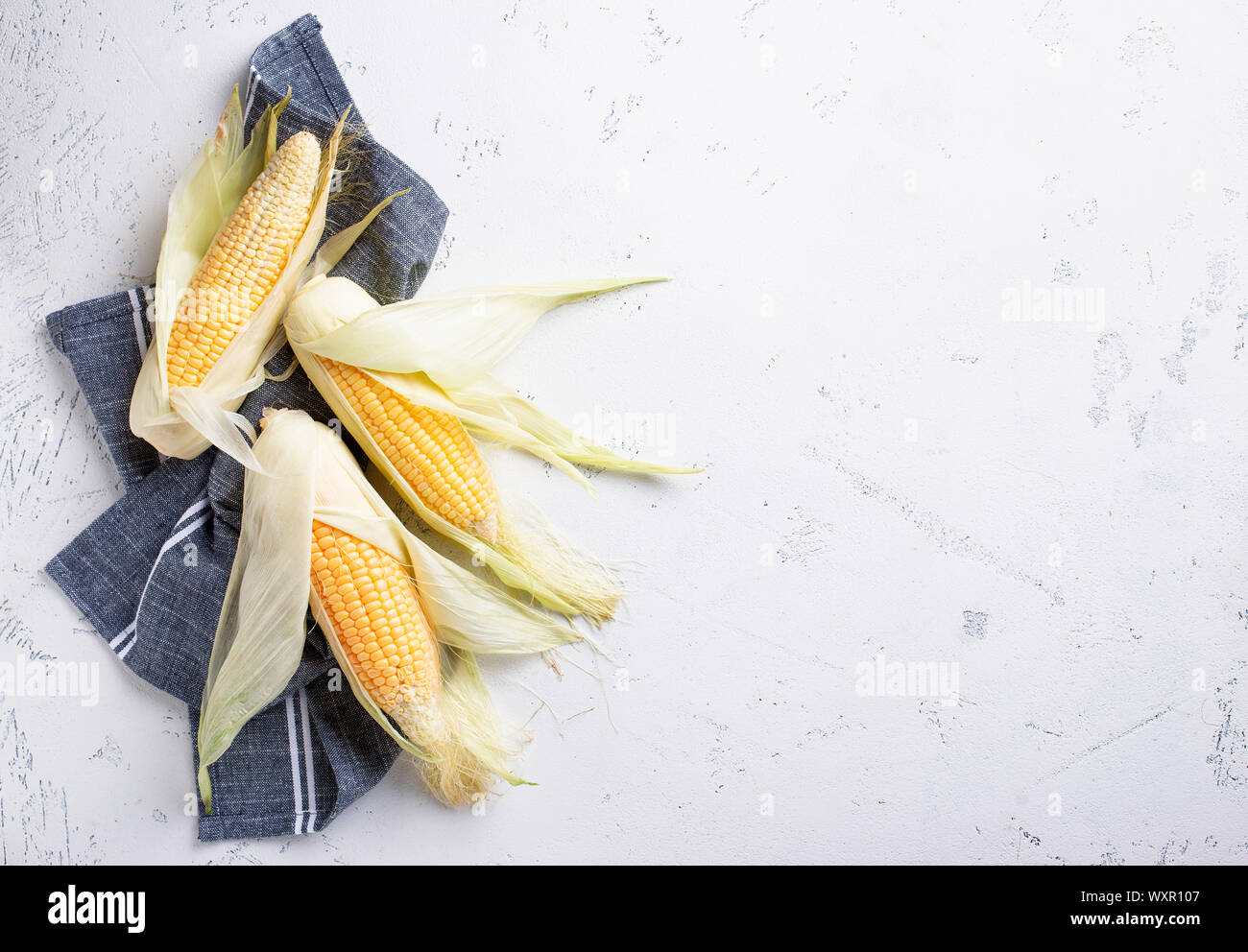 Raw corn on concrete table Stock Photo - Alamy
