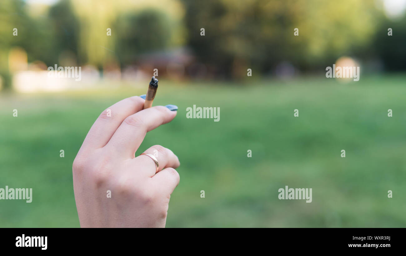 Close-up of females hands holding marijuana joint, smoking cannabis ...