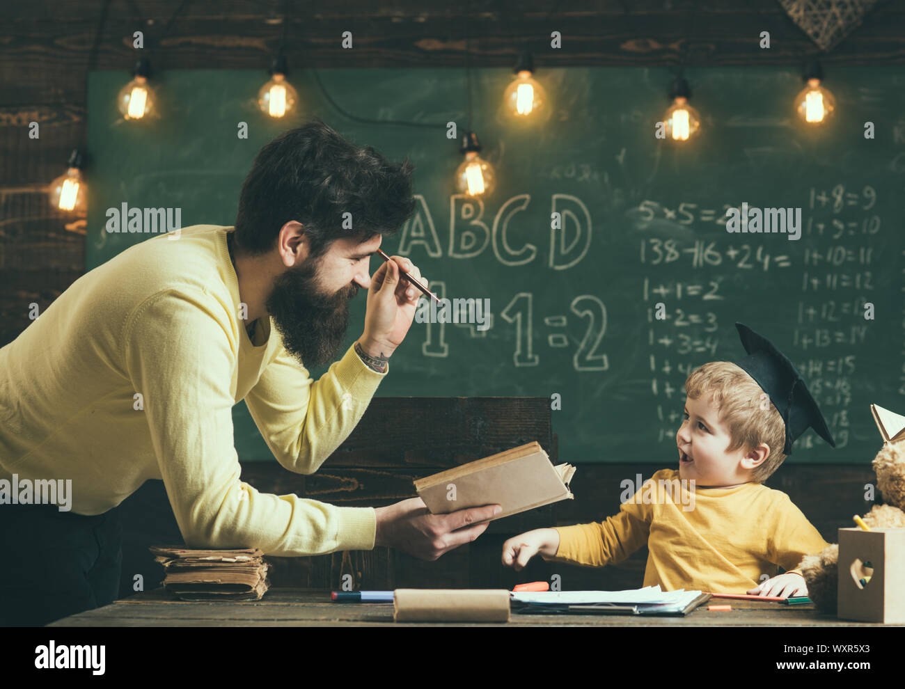 Wunderkind and genius concept. Father, teacher reading book, teaching ...
