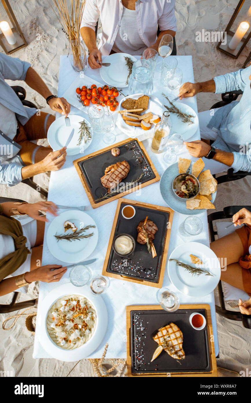 Group of friends having a festive dinner at the beautifully decorated ...