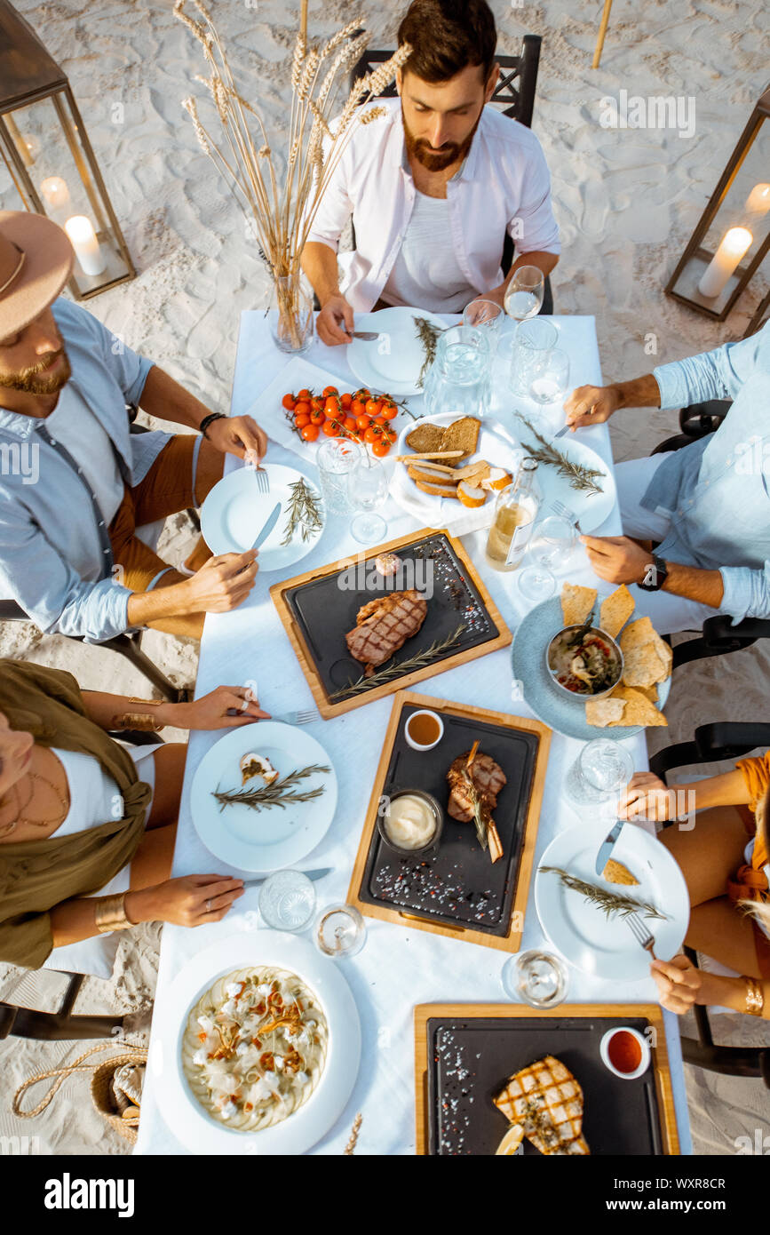 Group of friends having a festive dinner at the beautifully decorated ...