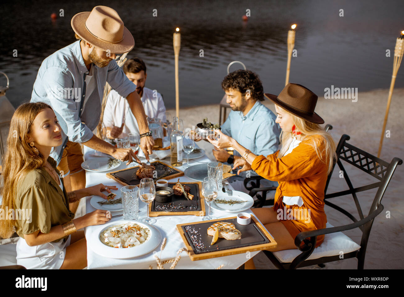 Group of friends having a festive dinner at the beautifully decorated ...