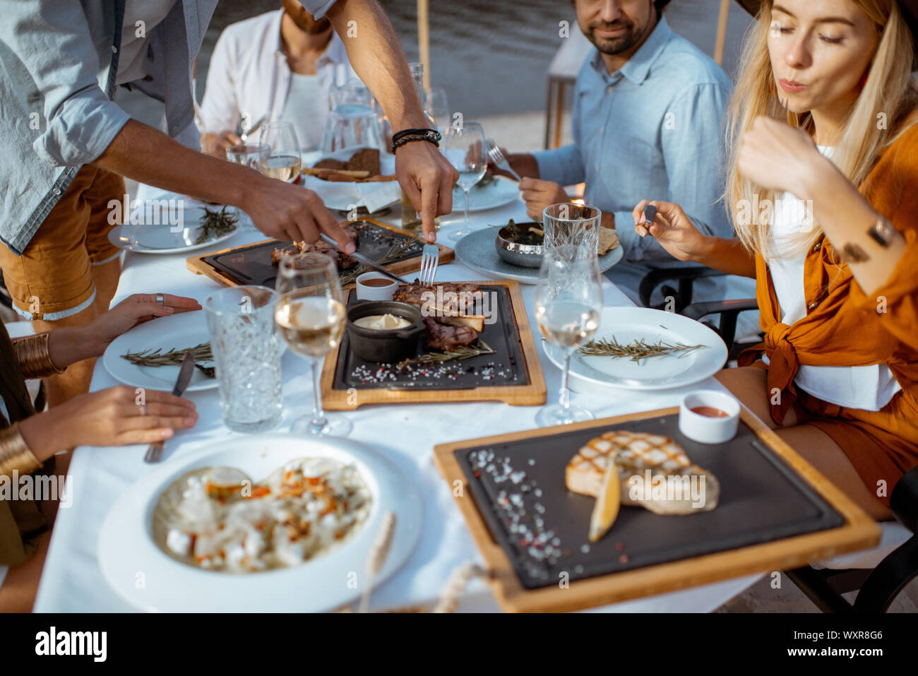 Group of friends having a festive dinner at the beautifully decorated ...