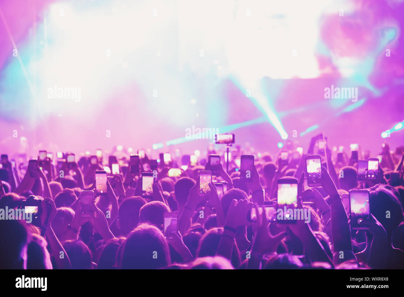 People taking photographs with touch smart phone during a music ...