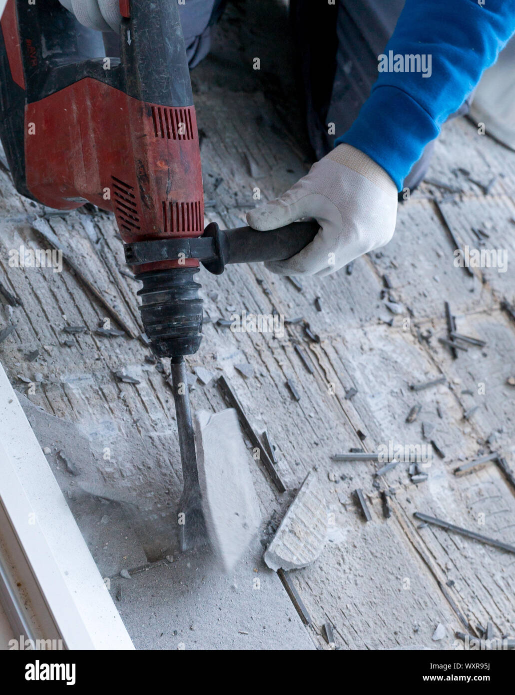 detail view of a construction worker using a handheld demolition hammer ...