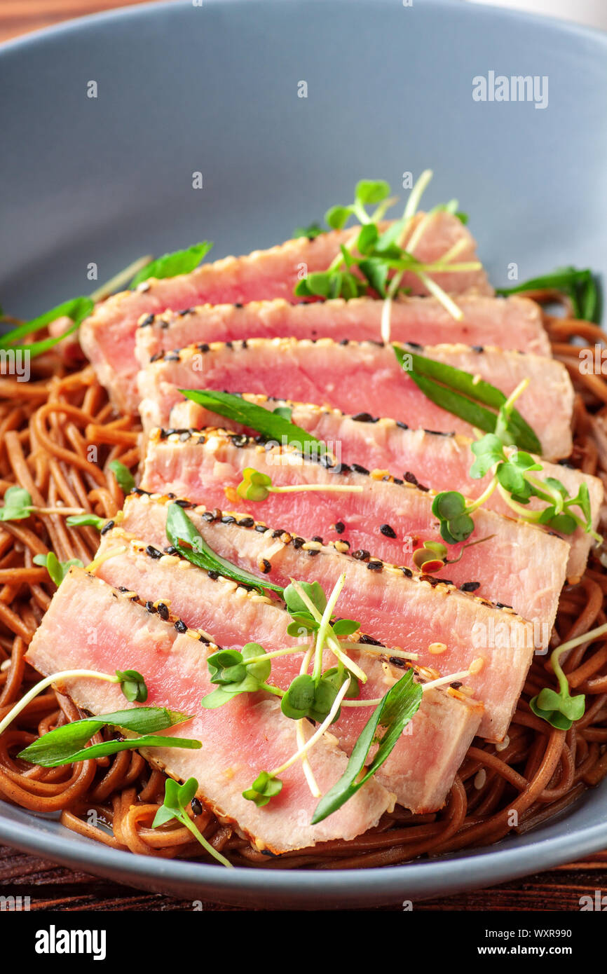 Japanese buckwheat soba noodles with sliced tuna with sesame on dark ...