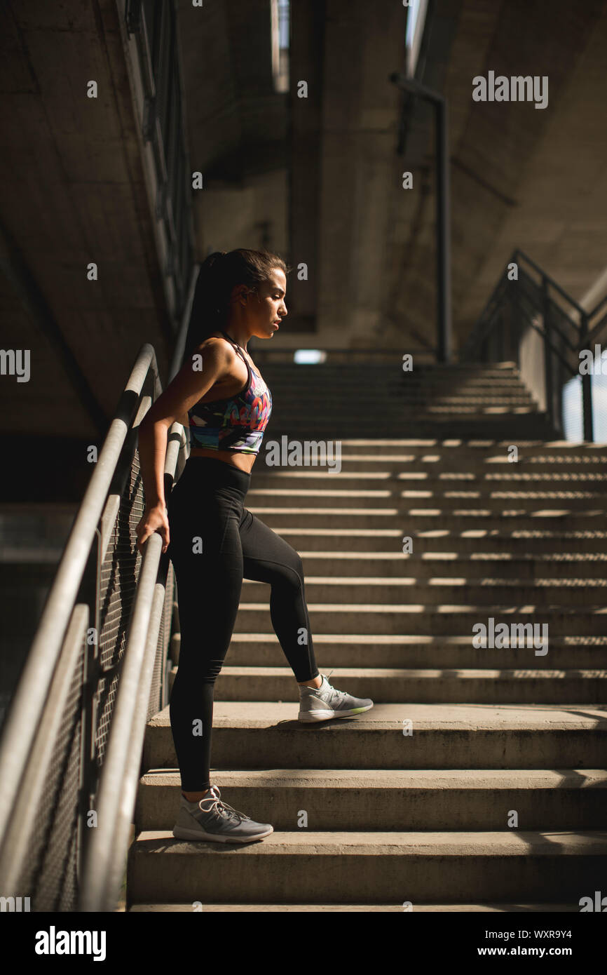 Portrait of pretty young female runner resting on stairs Stock Photo ...