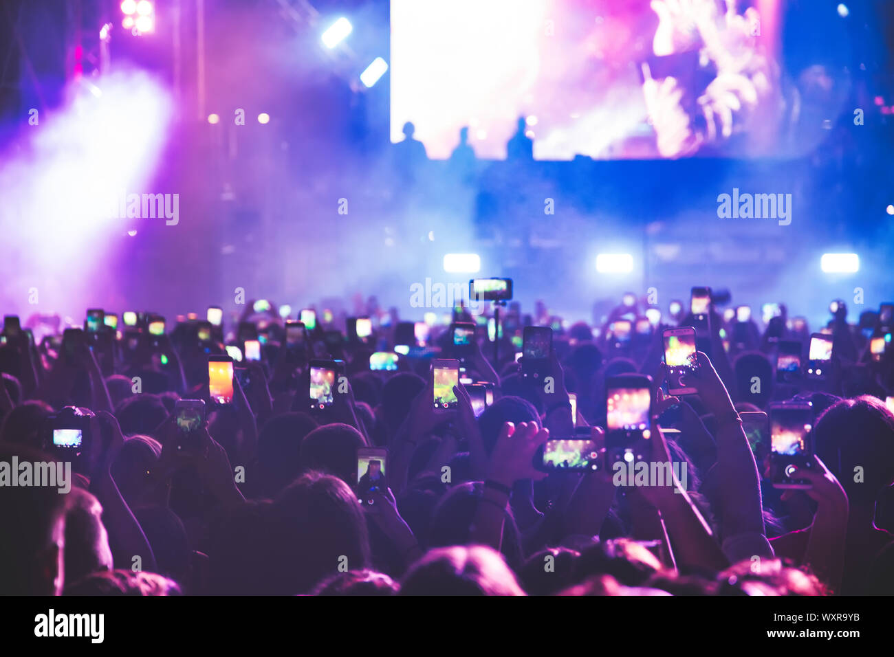 People taking photographs with touch smart phone during a music ...